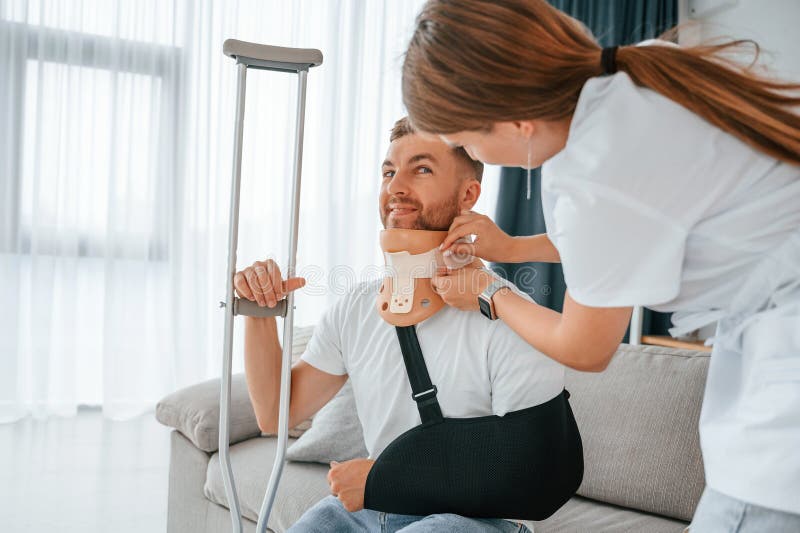 Nurse is Helping Injured Man at Home Stock Photo - Image of domestic ...