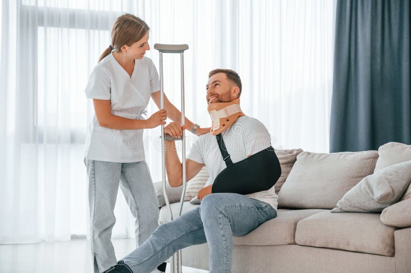 Nurse is Helping Injured Man at Home Stock Photo - Image of home ...