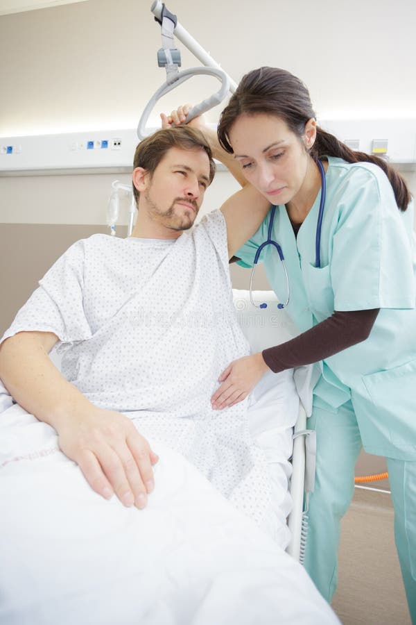 Nurse Helping Sick Male Patient Lying on Bed Stock Photo - Image of ...