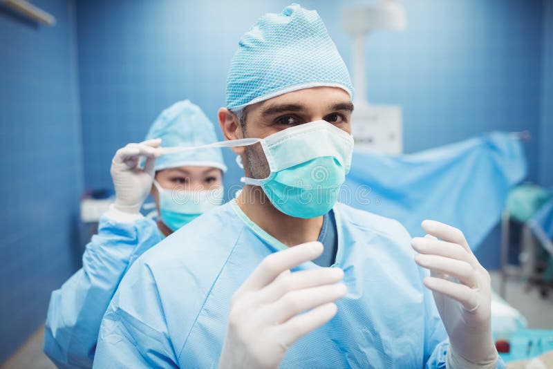 Nurse Helping a Surgeon in Tying Surgical Mask Stock Image - Image of ...