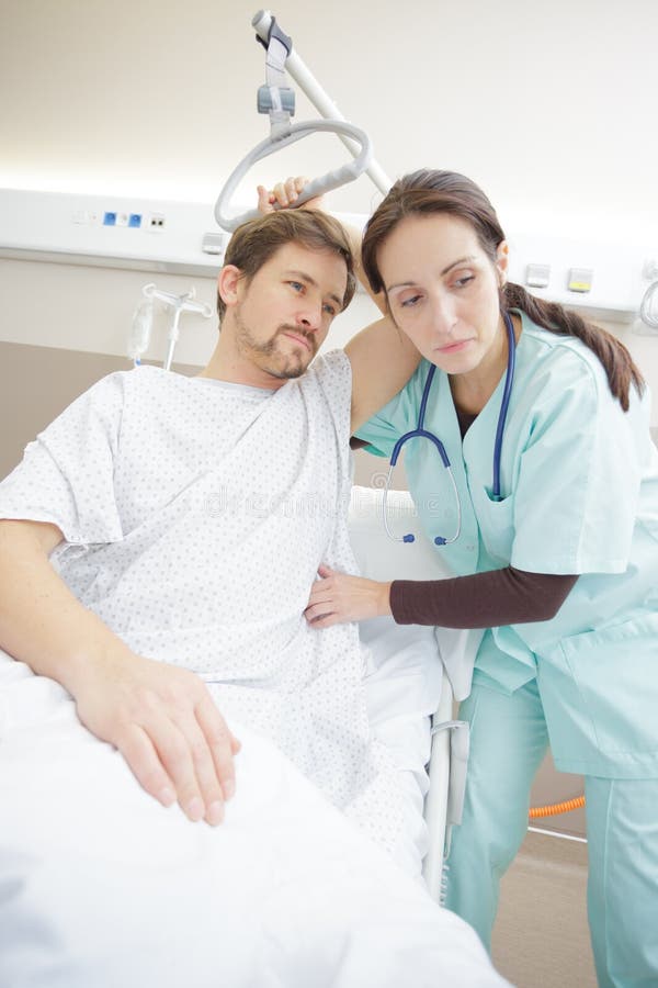 Nurse Helps Sick Male Patient Out Bed Stock Photo - Image of ...