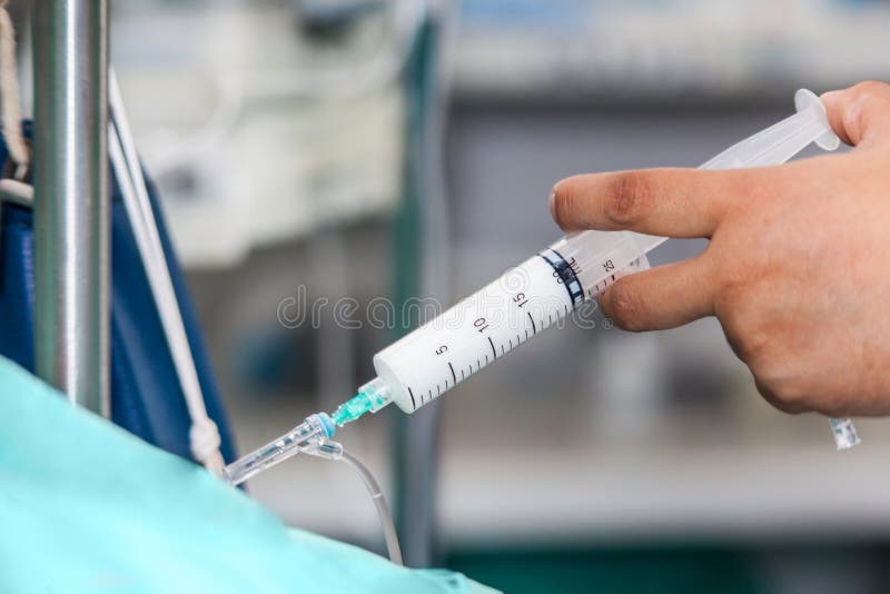 Nurse Injecting a Drug through an Infusion System Stock Photo - Image ...
