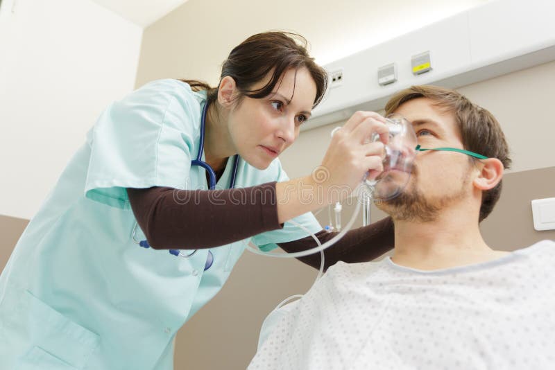 Nurse Placing Oxygen Mask on Patient in Hospital Stock Photo - Image of ...