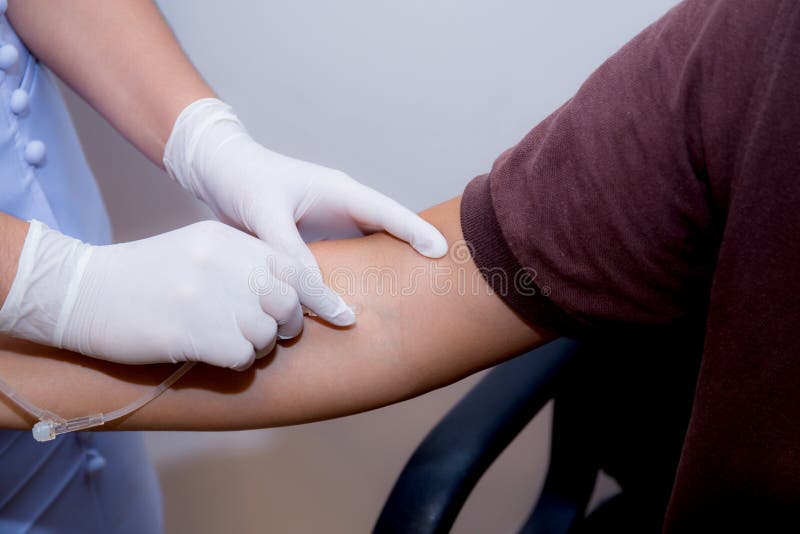 Nurse Putting an IV Needle into a Patients Hand. Stock Image - Image of ...