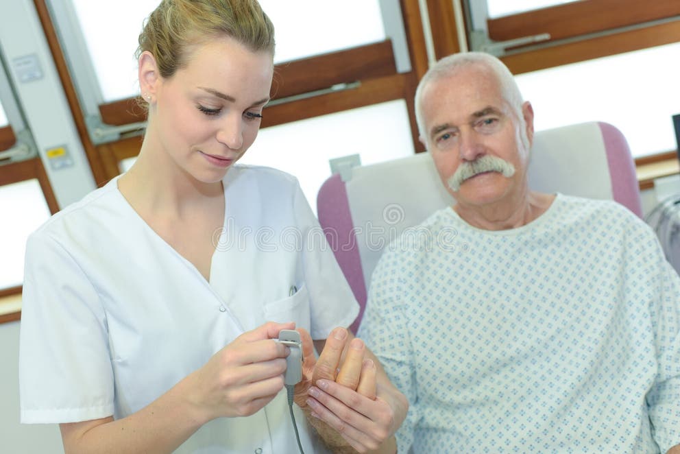 Nurse Putting Pulse Reader on To Patients Finger Stock Photo - Image of ...