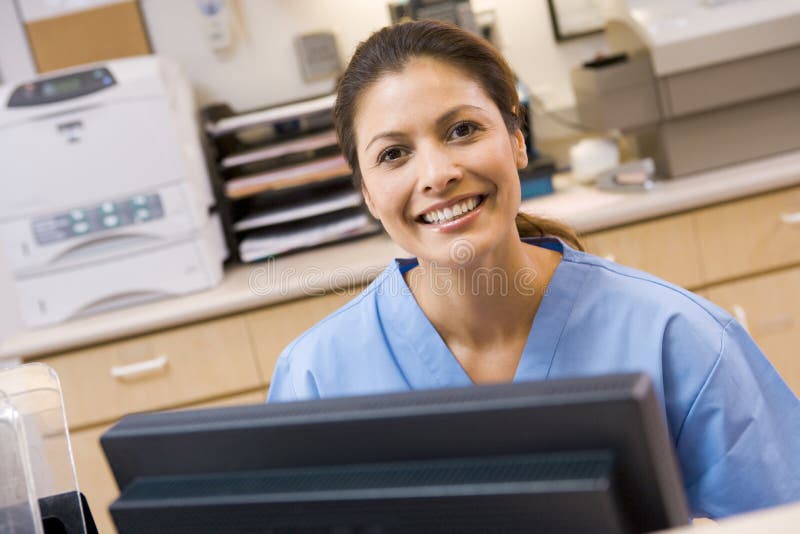 A Nurse Sitting at a Computer Stock Photo - Image of scrubs, confidence ...