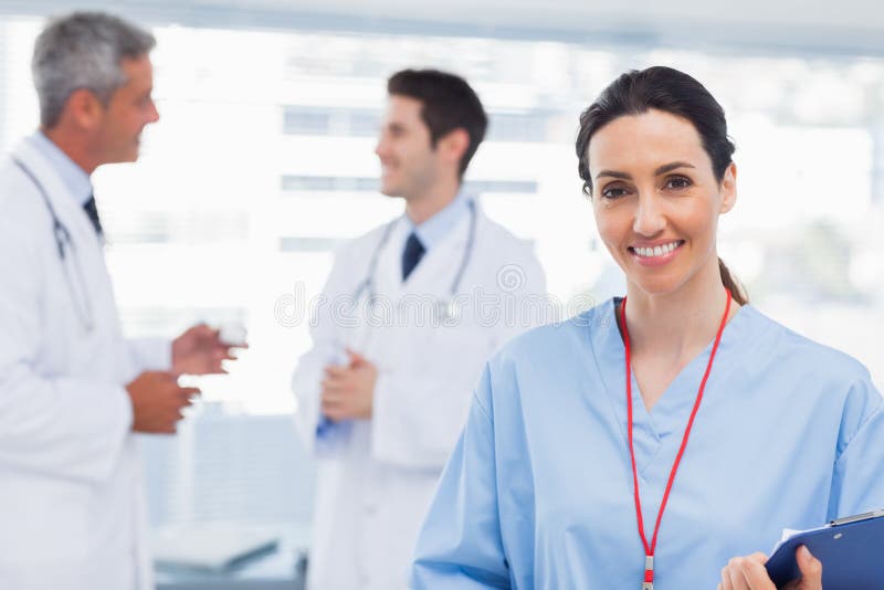Nurse Smiling at Camera while Doctors are Talking Together Stock Image ...