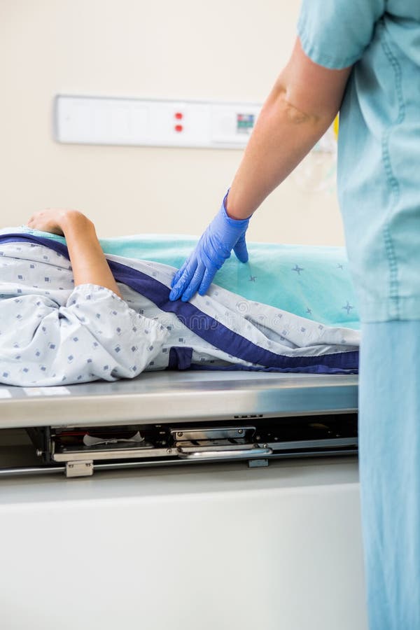 Nurse Standing by Patient Lying on Xray Table Stock Image - Image of ...