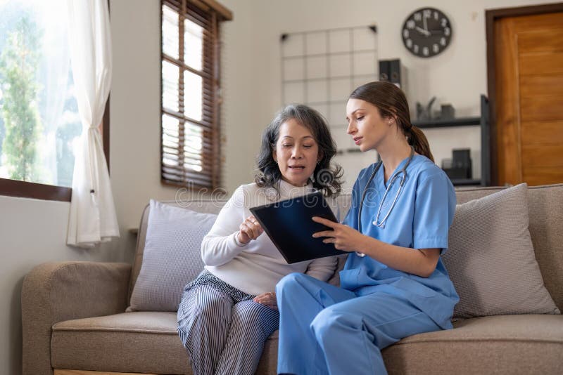 Nurse Taking Notes during Home Visit with Senior Female Patient Stock ...