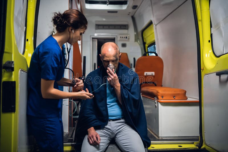Nurse With Stethoscope And Man Sits In Oxygen Mask In Blanket In The