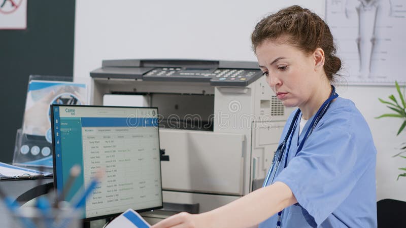 Nurse Using Computer with Appointments at Reception Desk Stock Photo ...