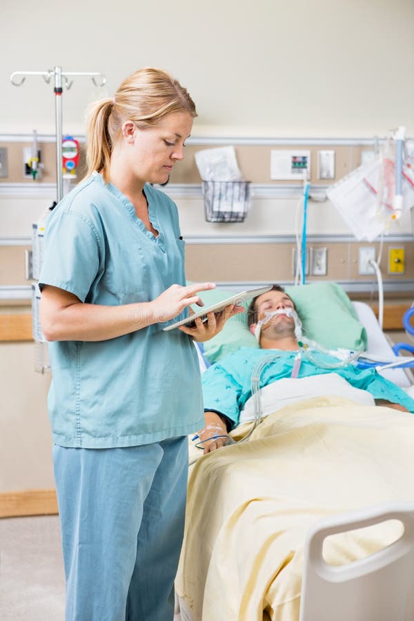 Nurse Using Digital Tablet while Patient Resting Stock Photo - Image of ...