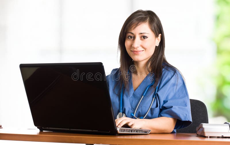 Doctor in Scrubs Using Computer at Hospital Desk Stock Image - Image of ...