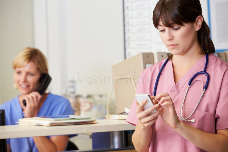 Nurse Using Mobile Phone at Nurses Station Stock Image - Image of care ...