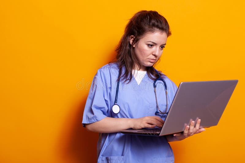 Nurse Using Technology on Modern Laptop and Wearing Uniform Stock Photo ...