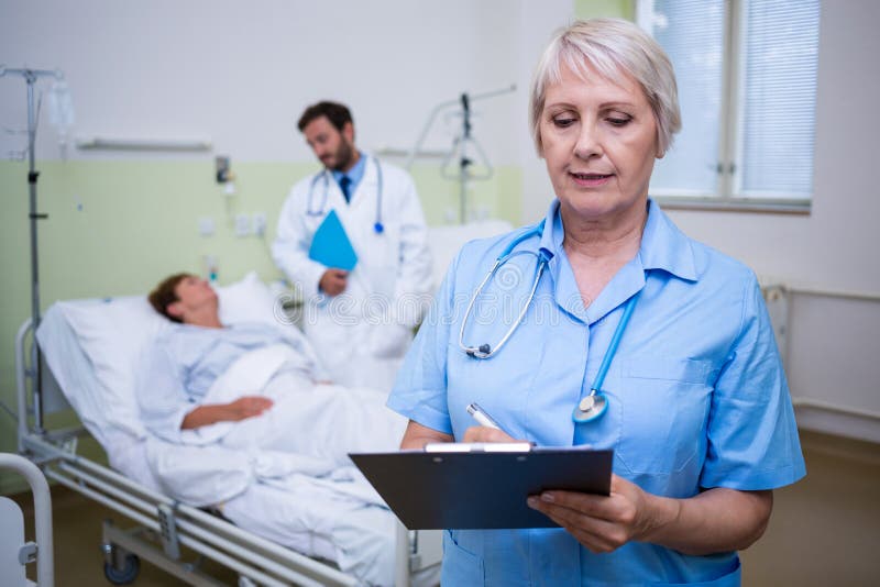 Nurse writing on clipboard stock photo. Image of adult - 77227824