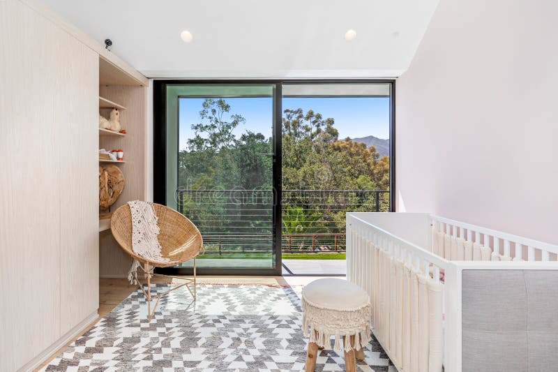 A Nursery that Has Windows and Furniture in it with a Crib Stock Image ...