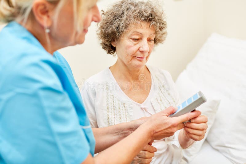 Nursing Helps Elderly with the Remote Control Stock Photo - Image of ...