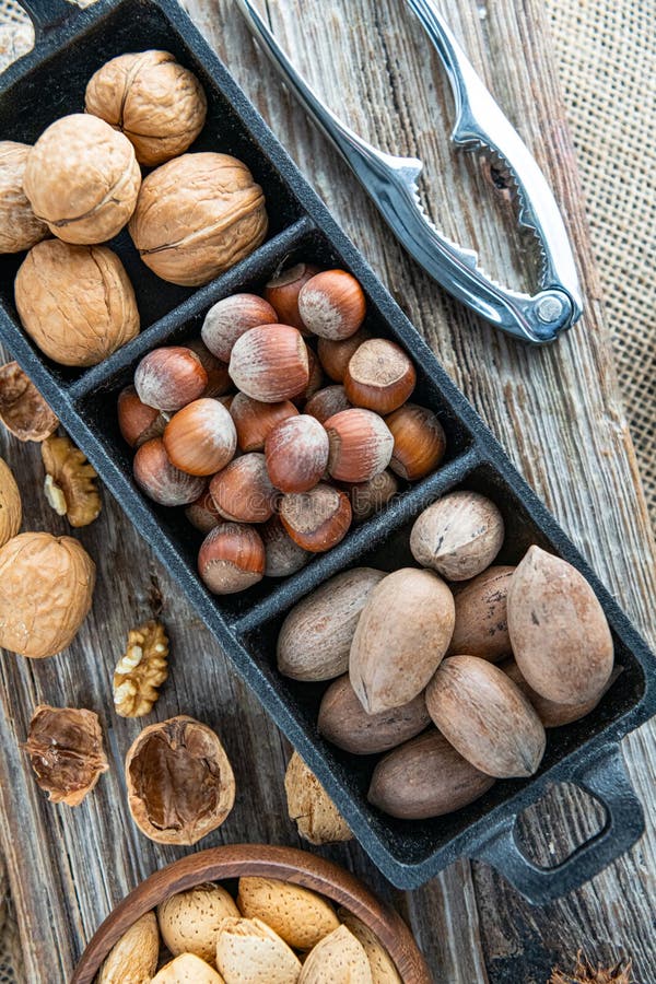 Nutcracker Cracking Nuts and Assorted Nuts in a Plate on a Dark Wooden ...