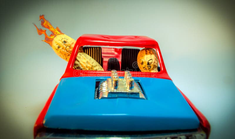 Funny Peanuts with Drawn Faces Driving a Toy Car with His Head on Fire ...