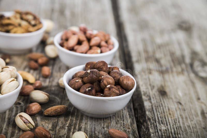 Nuts in a Plate on a Wooden Table. Stock Photo - Image of dried ...