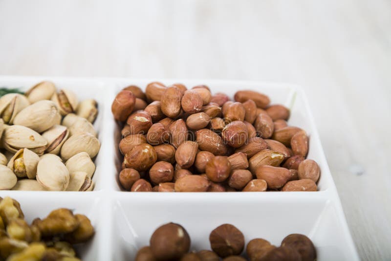 Nuts in a Plate on a Wooden Table. Stock Image - Image of food ...