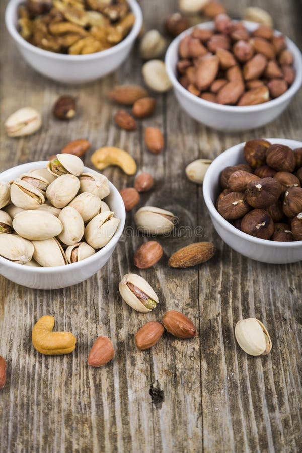Nuts in a Plate on a Wooden Table. Stock Image - Image of peanuts ...