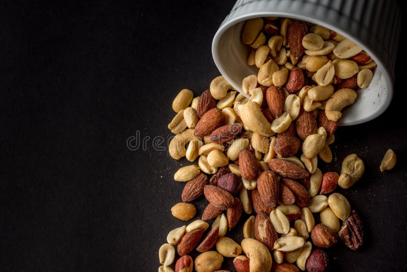 Nuts Poured Out from the Bowl in Black Background Stock Photo - Image ...