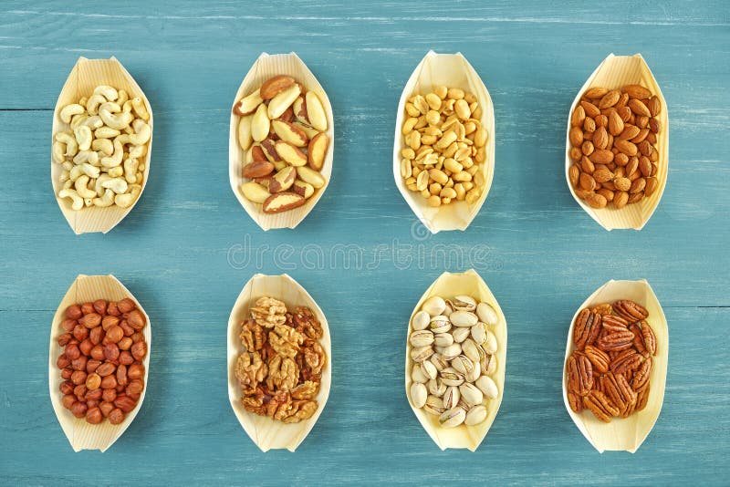 Nuts Selection in Wooden Bowls on Blue Rustic Table. Stock Photo ...