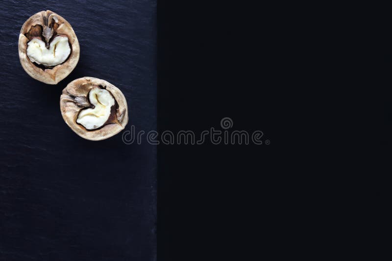 Nuts. Walnut Kernels and Whole Walnuts on Dark Stone Table. Black ...