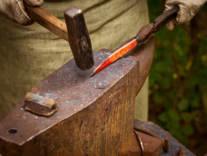 O Ferreiro Forja A Haste De Aço Encarnado No Batente Foto de Stock ...