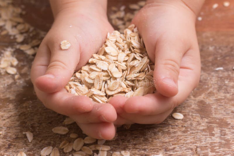 Oat flakes in a kids hand stock photo. Image of nature - 132953416