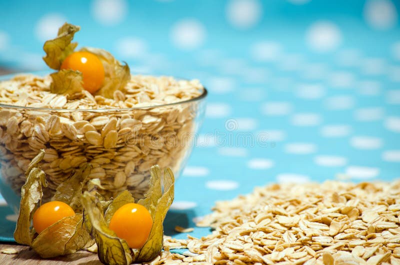 Oat Flakes Scattered on the Table and in the Bowl and Physalis Stock ...