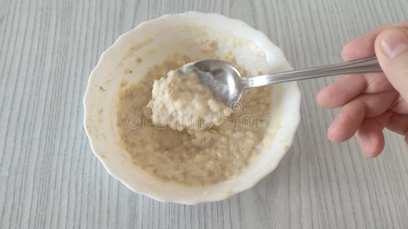 Oatmeal in a Plate. Man Stirs Porridge with a Spoon Stock Photo - Image ...