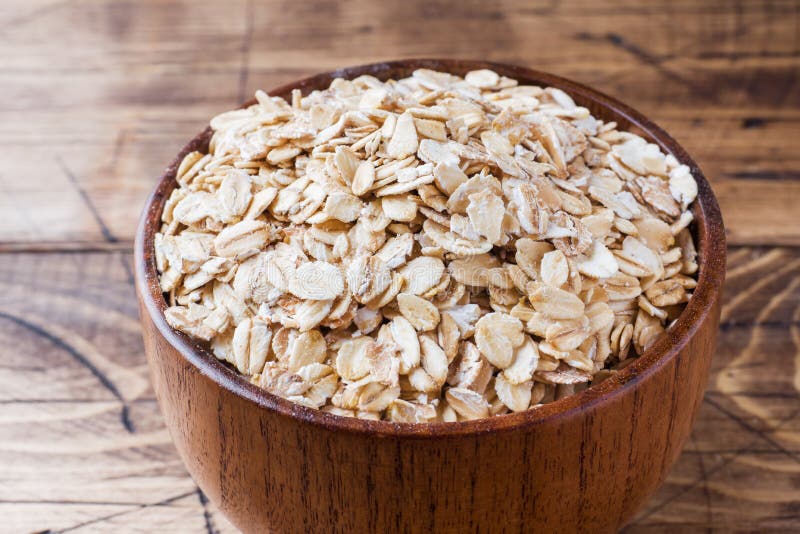 Oatmeal Raw in a Wooden Bowl on a Rustic Wooden Background. Stock Photo ...