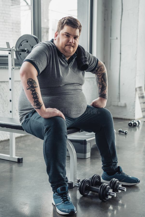 Obese Man Sitting on Bench and Looking at Camera after Exercising with ...