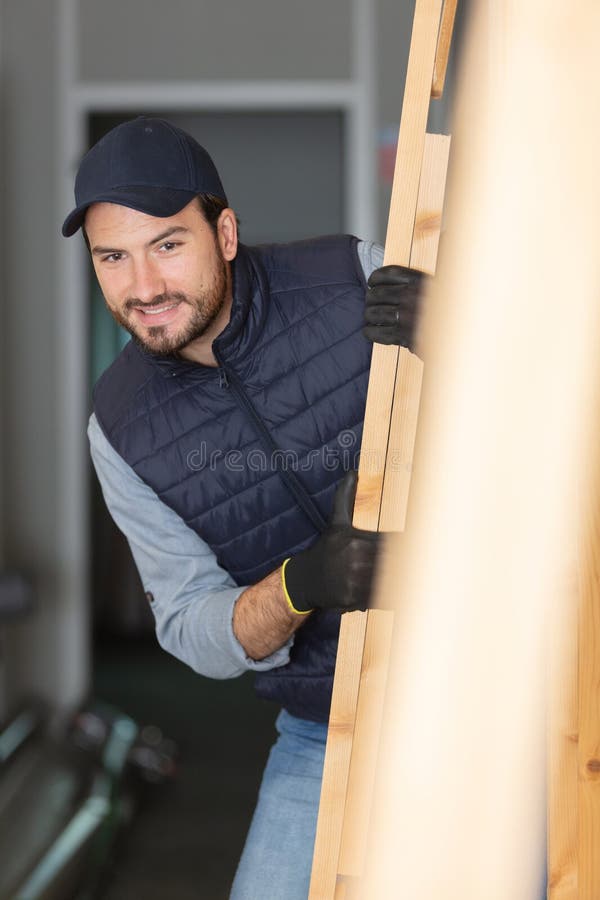 Obrero con madera larga foto de archivo. Imagen de trabajador - 279024086