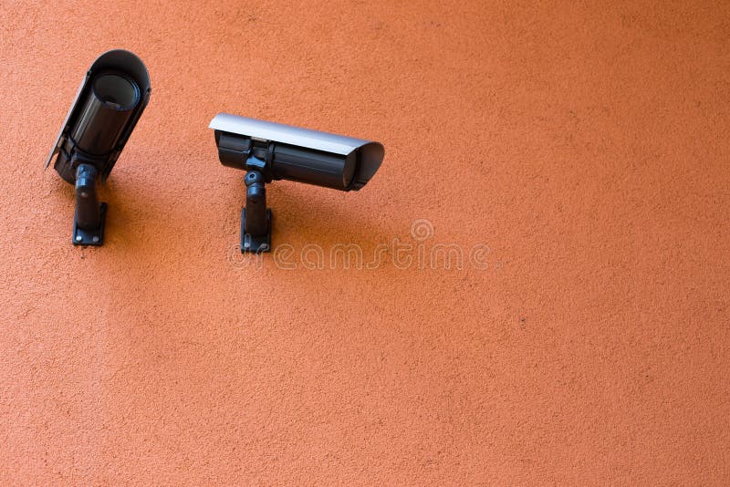 Observing Surveillance Cameras on Orange Wall Stock Image - Image of ...