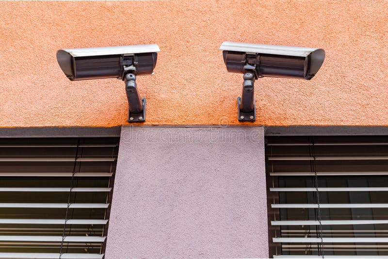 Observing Surveillance Cameras on Orange Wall Stock Image - Image of ...