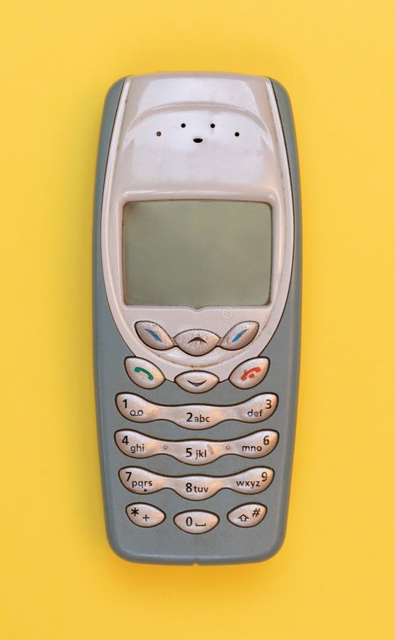 Obsolete Mobile Phone on a Yellow Background Stock Photo - Image of ...