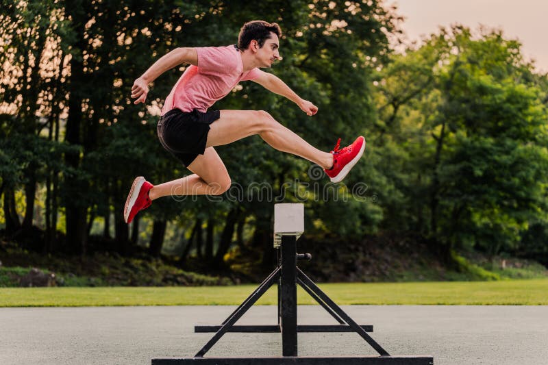 Obstacle Course Runner Jumping a Hurdle during Outdoors Training Stock ...