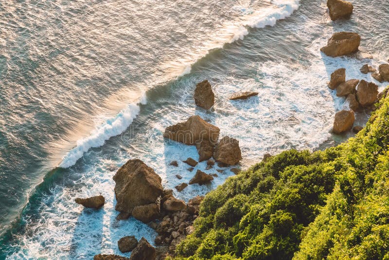 Ocean with Big Waves, Rocks and Cliff in Uluwatu at Warm Sunset Stock ...
