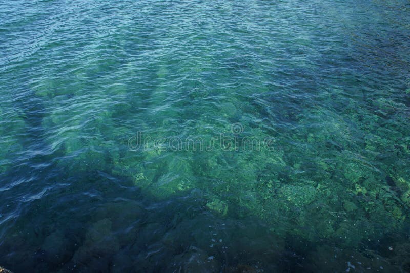 Clear Blue Water Laps Over Rocks on a Calm Day Stock Photo - Image of ...