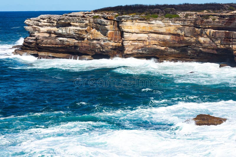 Oceanside Rocky Sandstone Cliff with Blue Sea Water Waves Creating ...