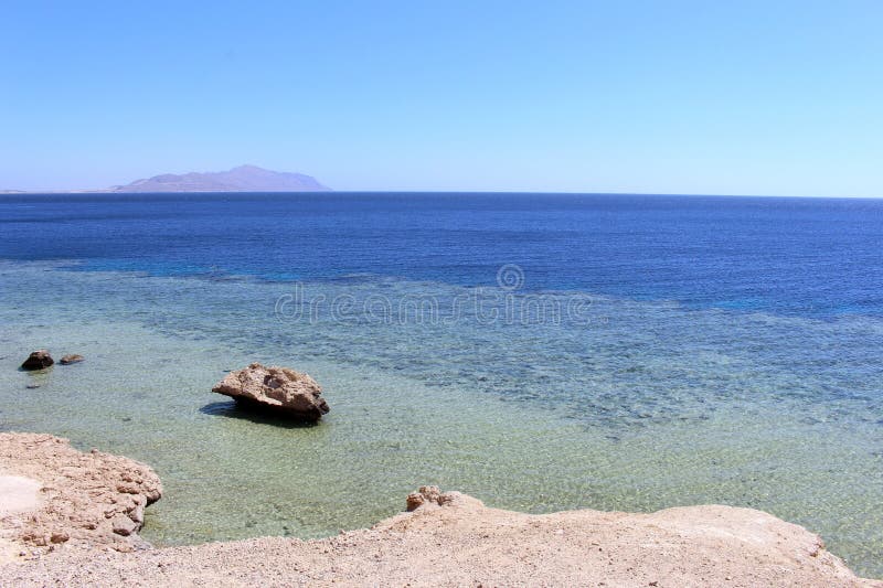 Ocean Cliff Panorama with Sandy Shores and Distant Mountains Under a ...