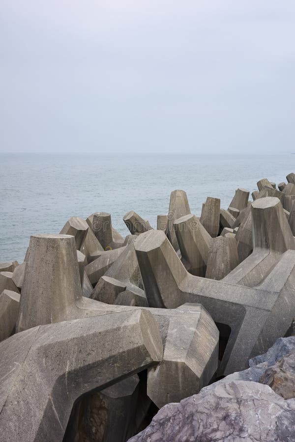 Ocean Defense Concrete Wave Breakers Along a Cloudy Coastline with Calm Sea Stock Image - Image ...