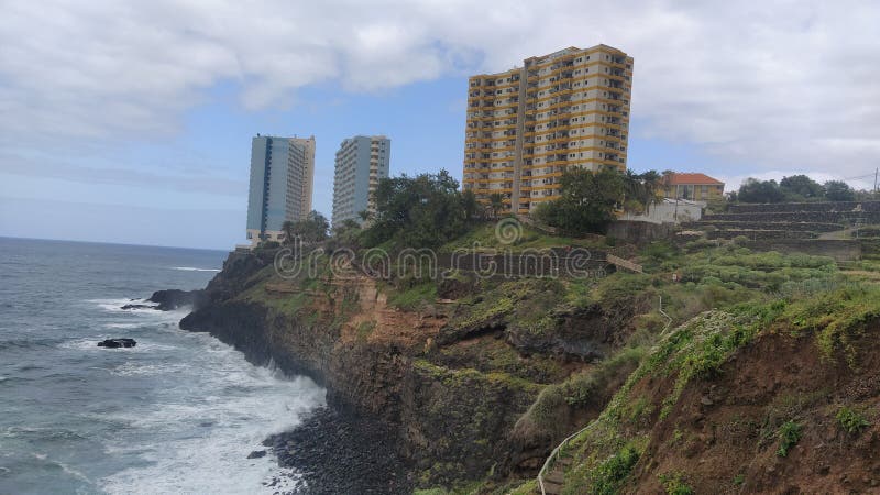 Ocean shore with buildings stock photo. Image of rock - 245609452