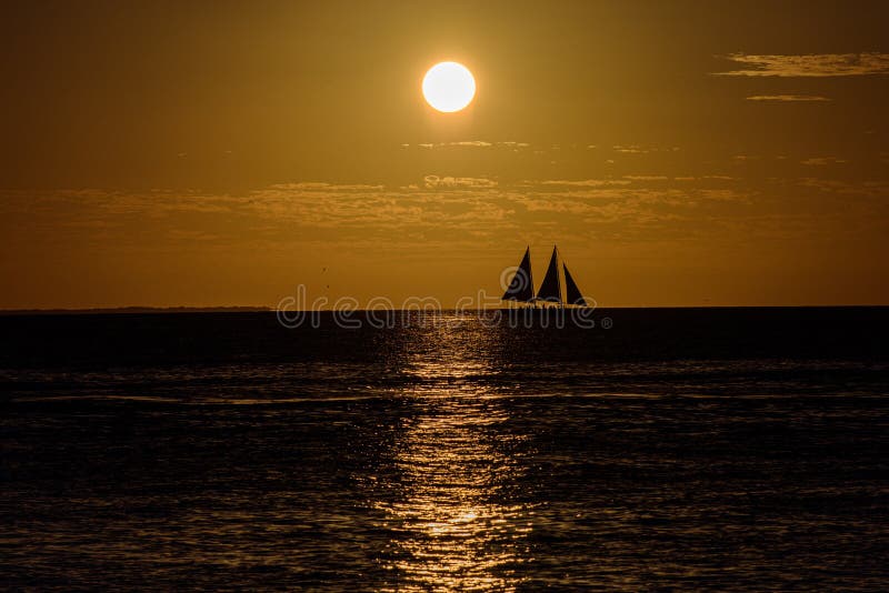 Ocean Sunset Sailboat Sailing Along the Ocean Water at Sunset. Sailing ...