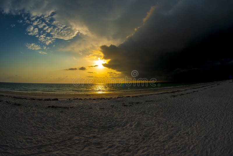 Ocean sunset with a storm stock image. Image of rocks - 99971489