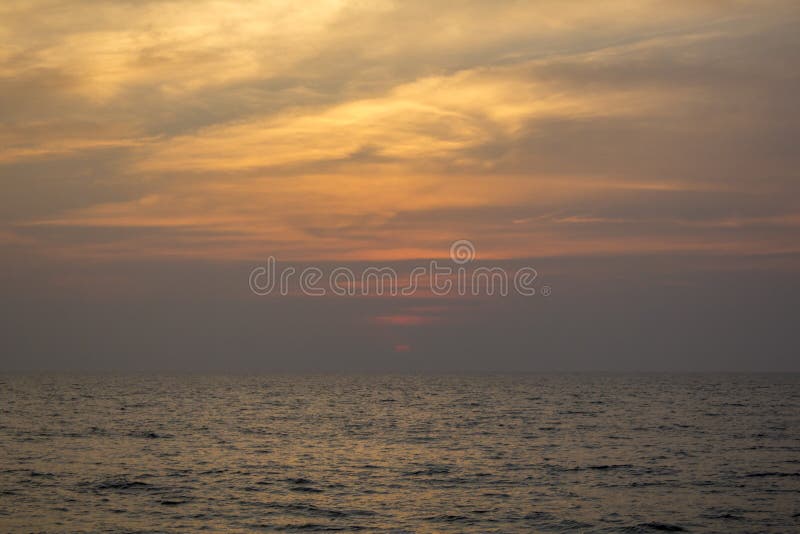 Ocean Under a Purple Sunset Sky with Bright Yellow Clouds Stock Photo ...